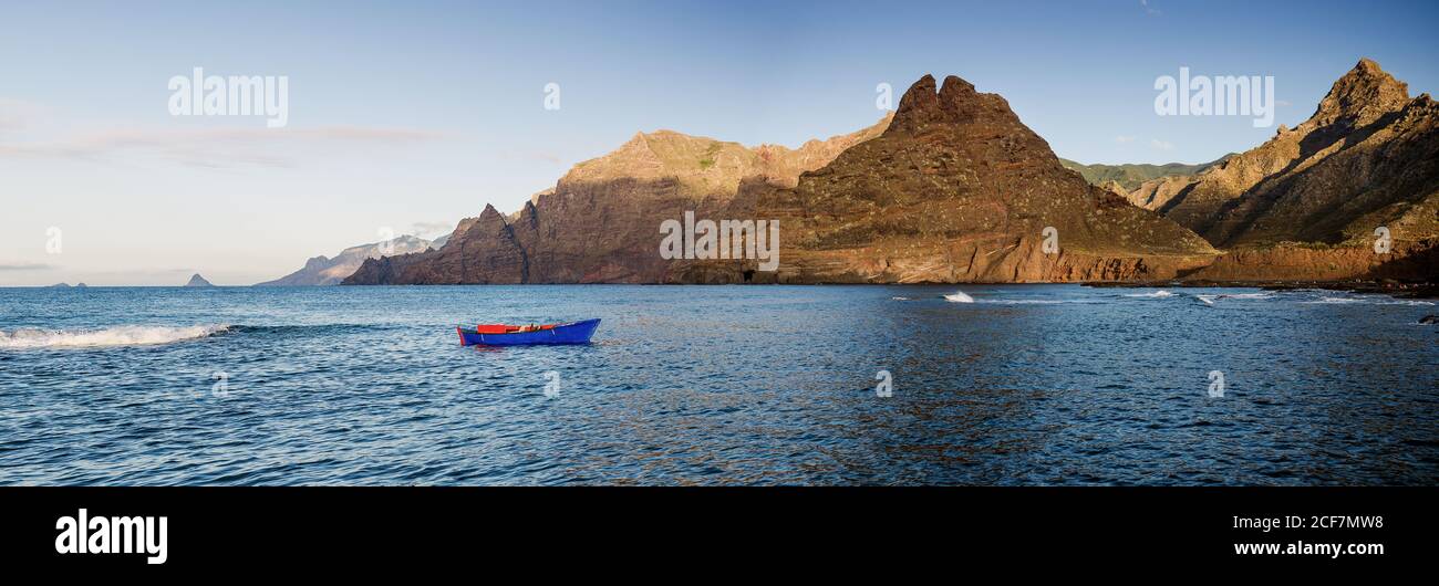 Blue sailboat in sea and beautiful rocks Stock Photo - Alamy