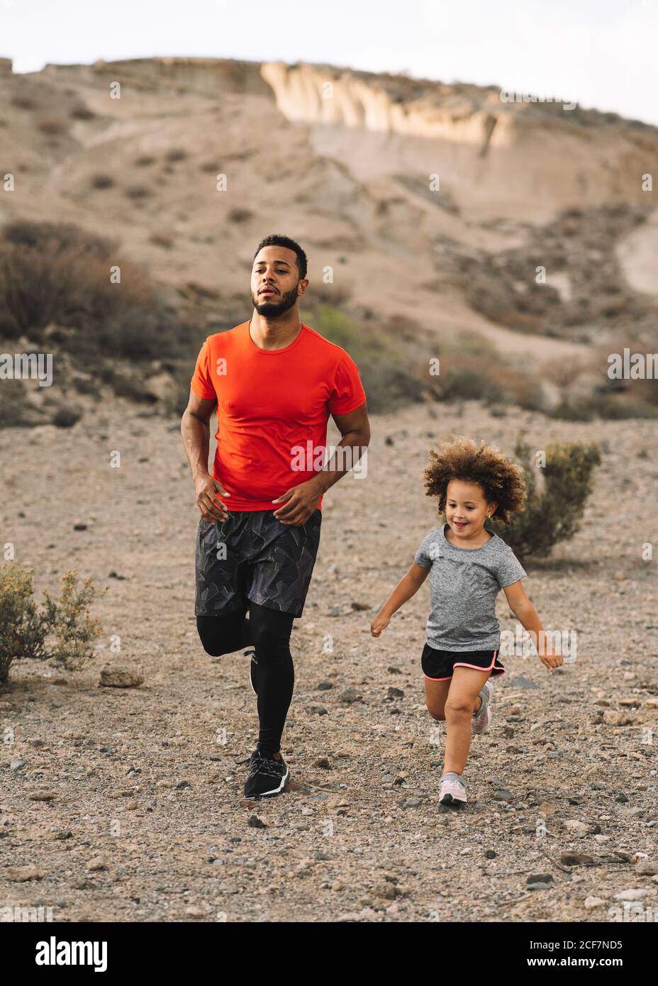 African American bearded active father in red t shirt running with ...