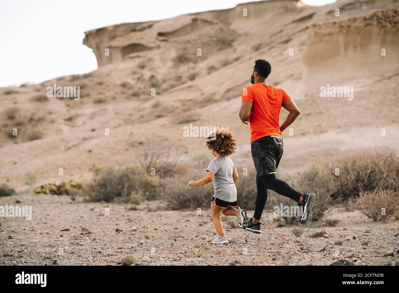African American bearded active father in red t shirt running with ...