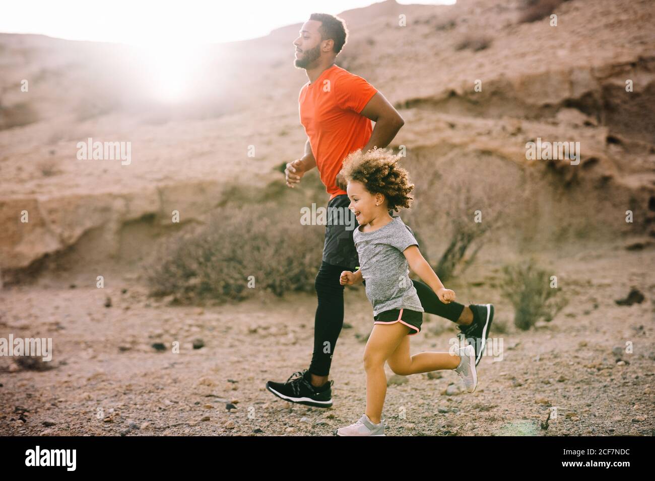 African American bearded active father in red t shirt running with ...