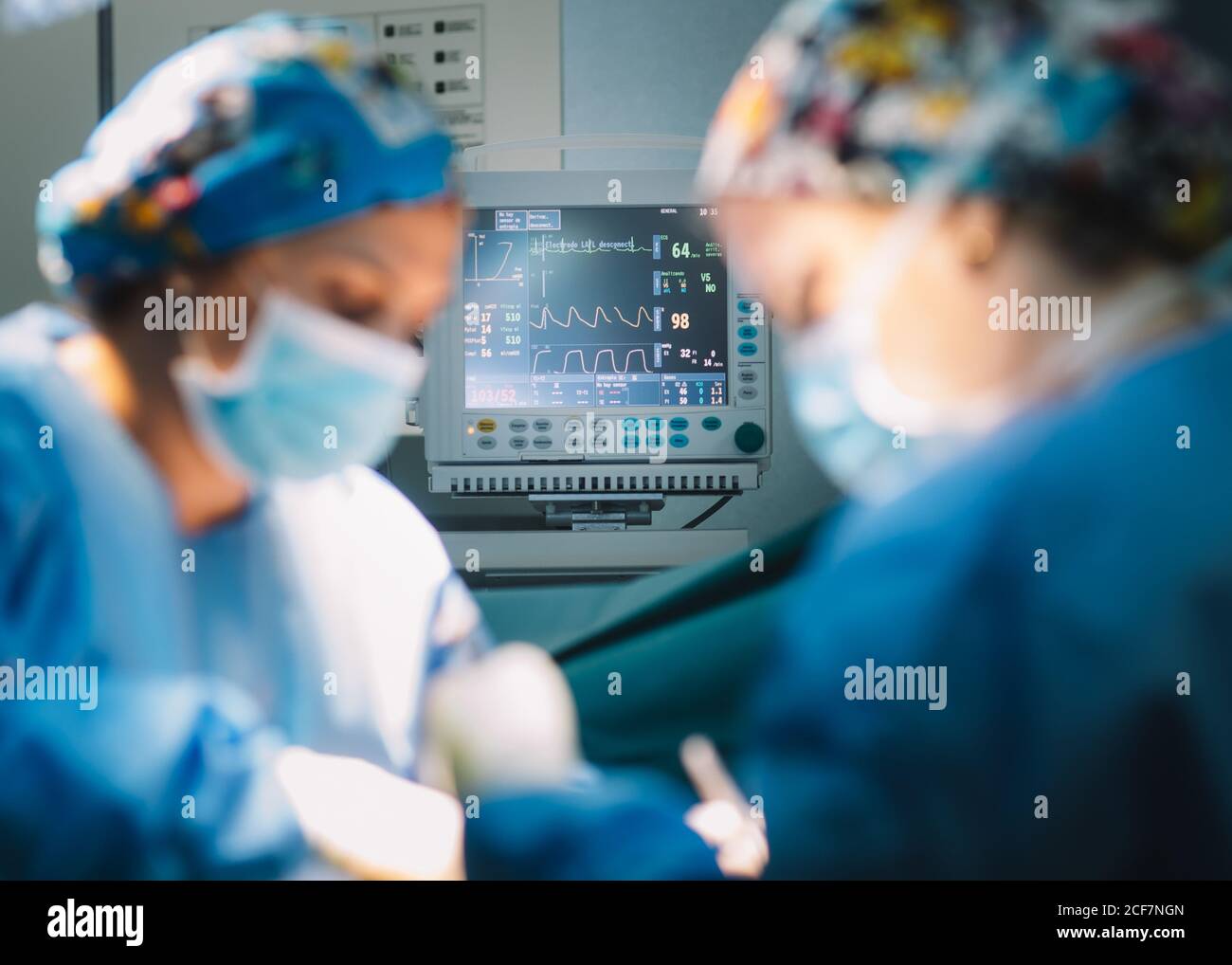 Modern monitor showing vital signs of patient while surgeon and ...