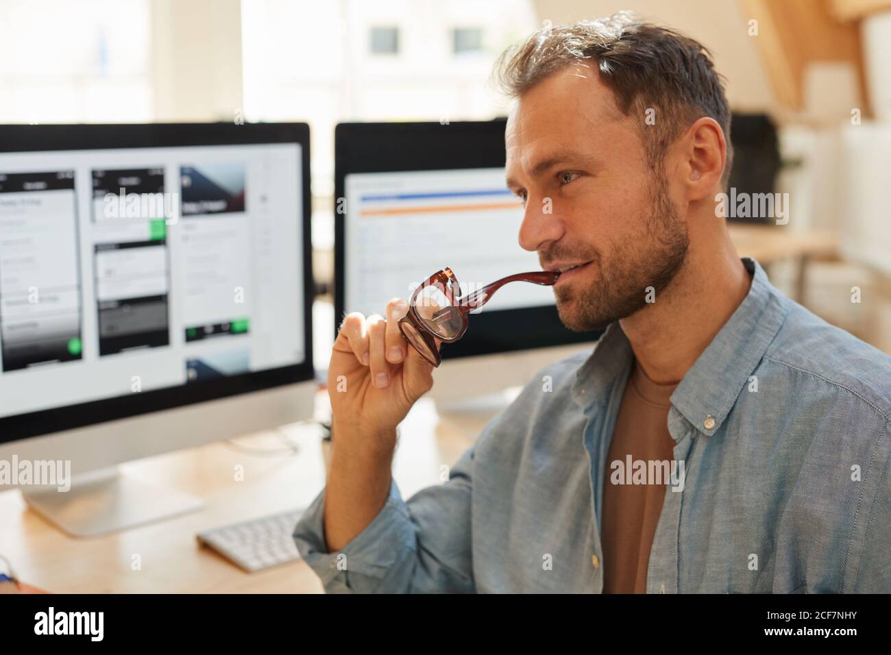 Mature businessman thinking over new project at his table with computer ...