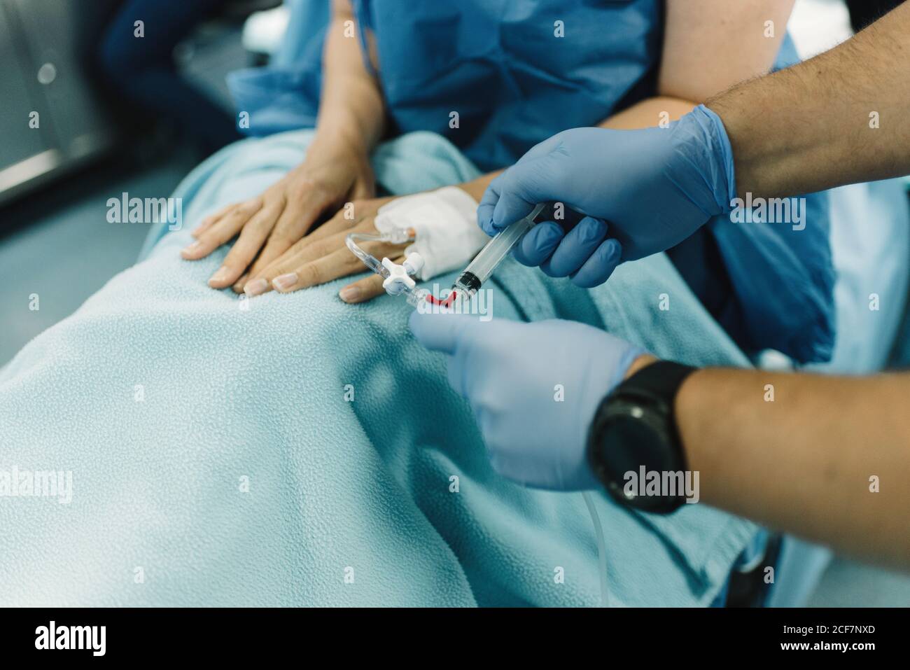 Crop female patient sitting with covered legs and intravenous fluid ...