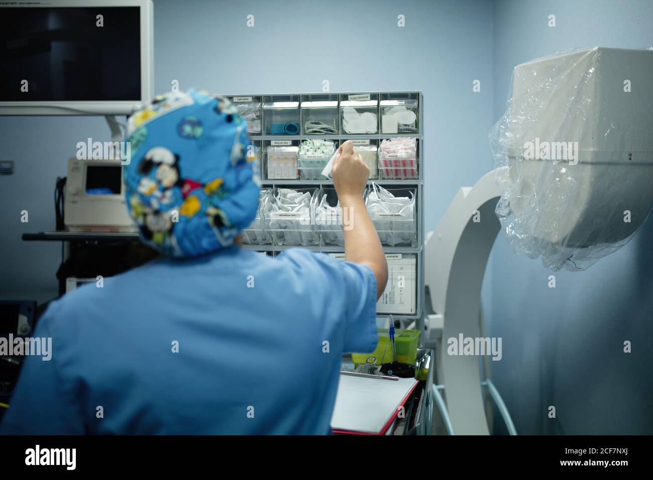 Back view of female medic in blue uniform taking supplies necessary for ...