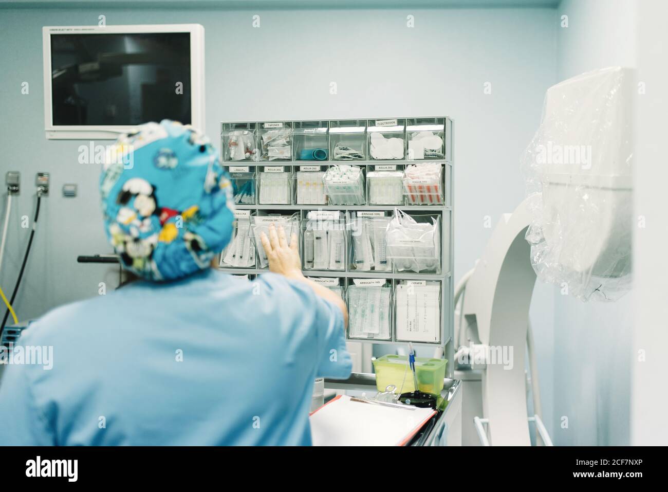 Back view of female medic in blue uniform taking supplies necessary for ...