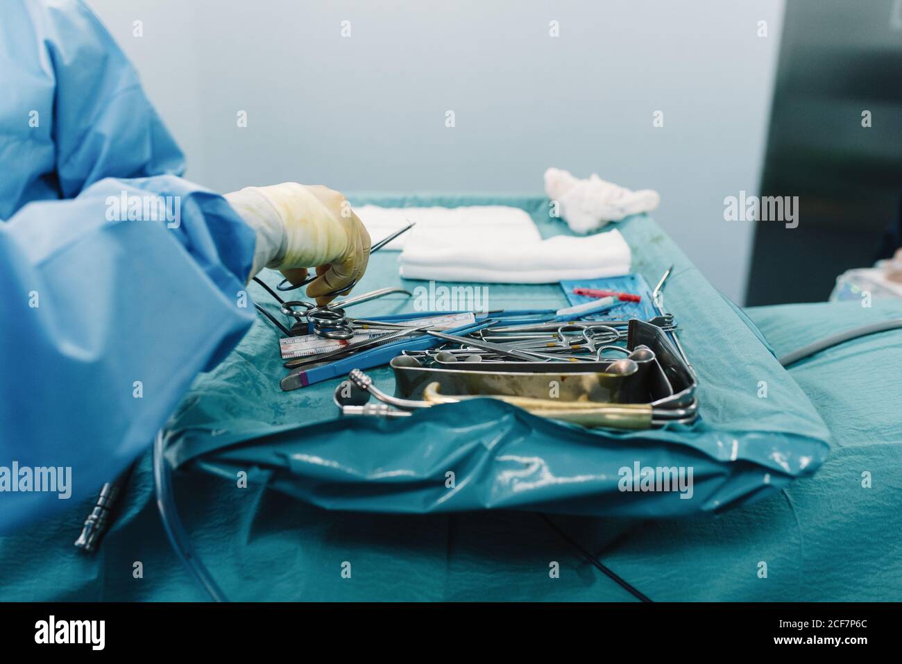 From above crop medic in uniform putting scissors on tray with ...