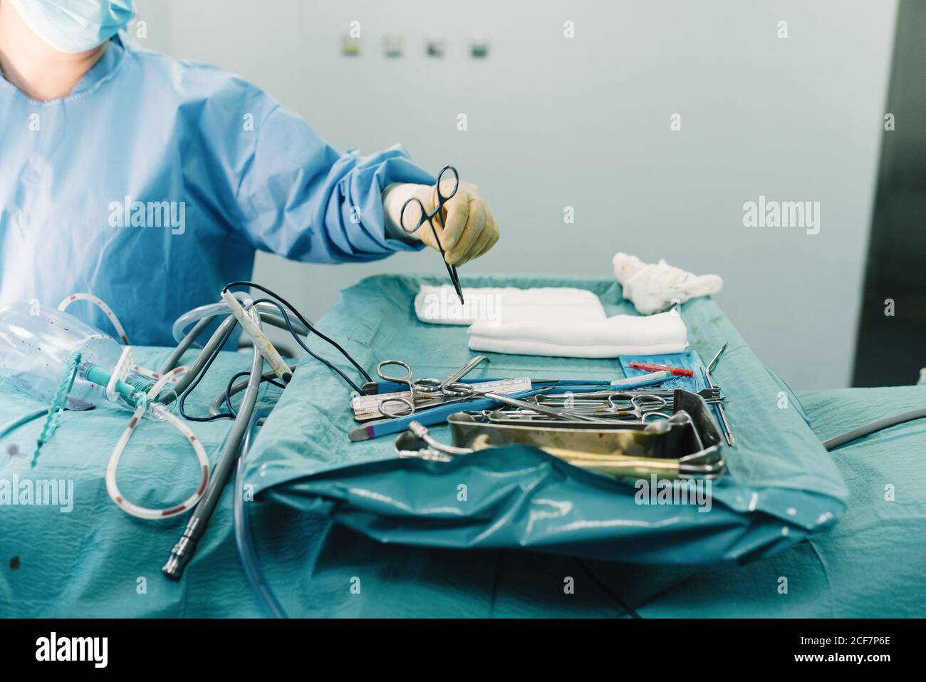 From above crop medic in uniform putting scissors on tray with ...