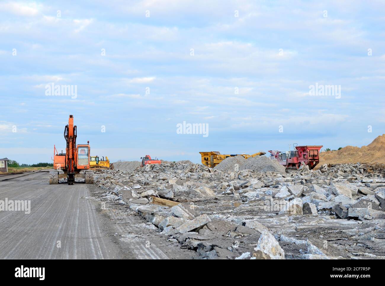 Excavator with a hydraulic hammer and shears destroys the road surface ...
