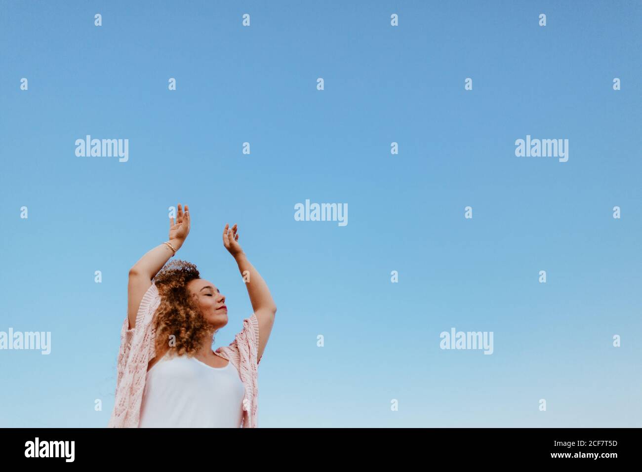 Happy Woman raising arms to sky Stock Photo - Alamy