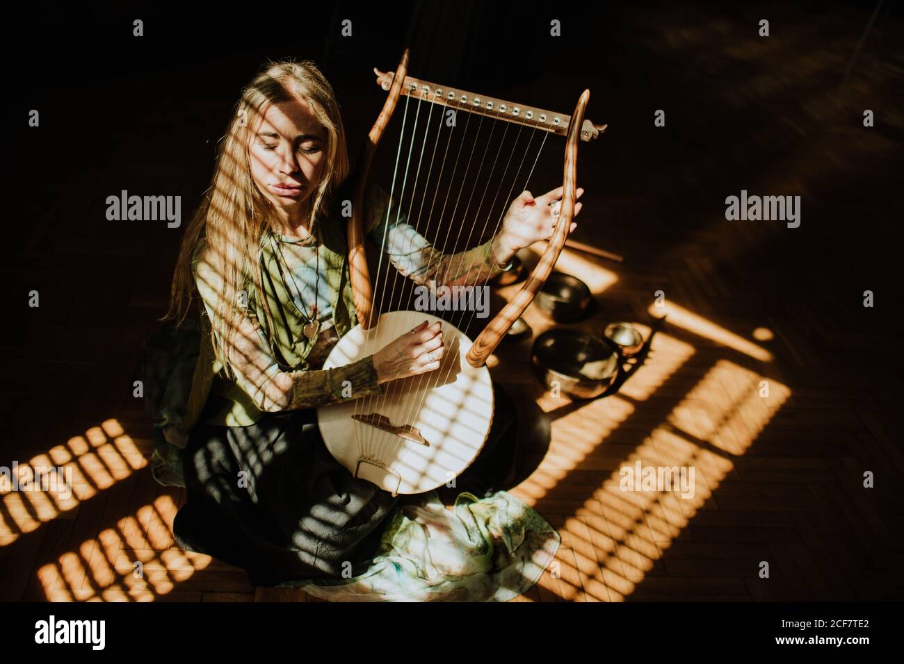 Lady playing lyre in dark room Stock Photo - Alamy