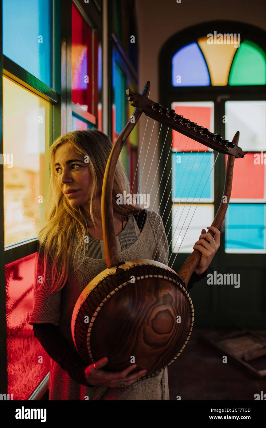 Woman with lyre standing near stained glass windows Stock Photo - Alamy