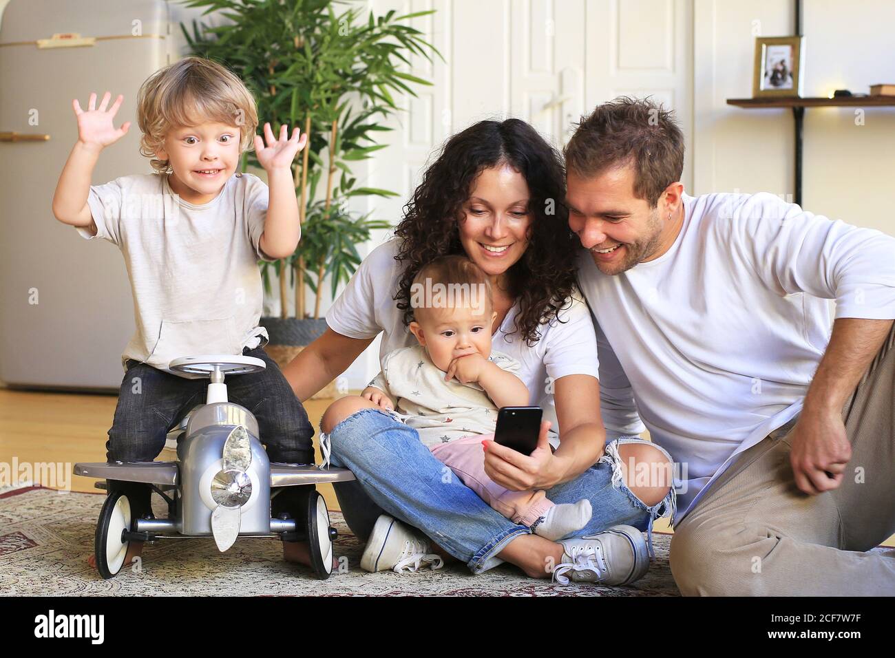 Young beautiful happy family relaxing at home Stock Photo - Alamy
