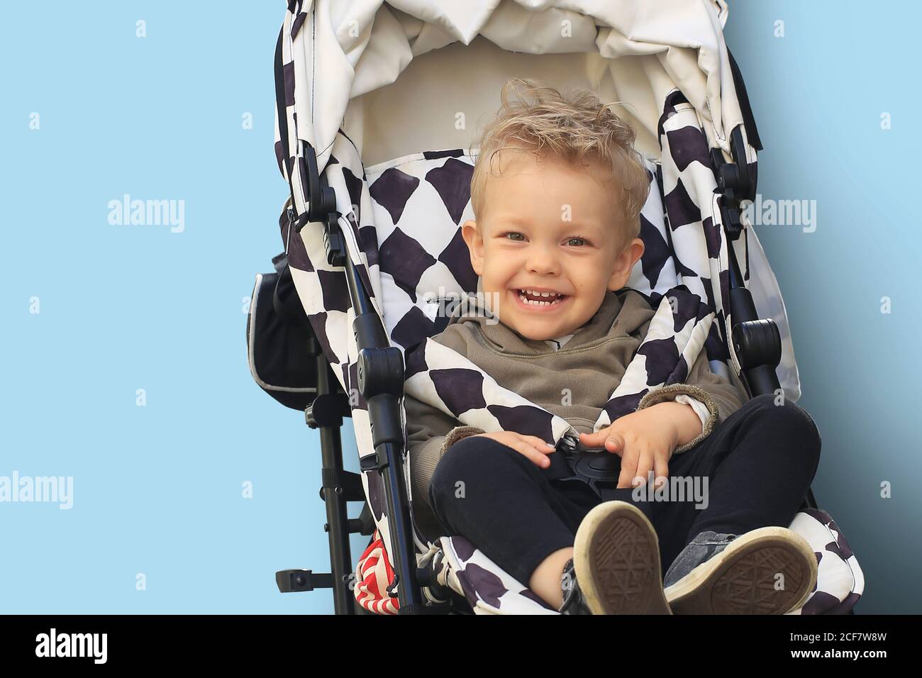 Little beautiful boy in a stroller on the street Stock Photo - Alamy