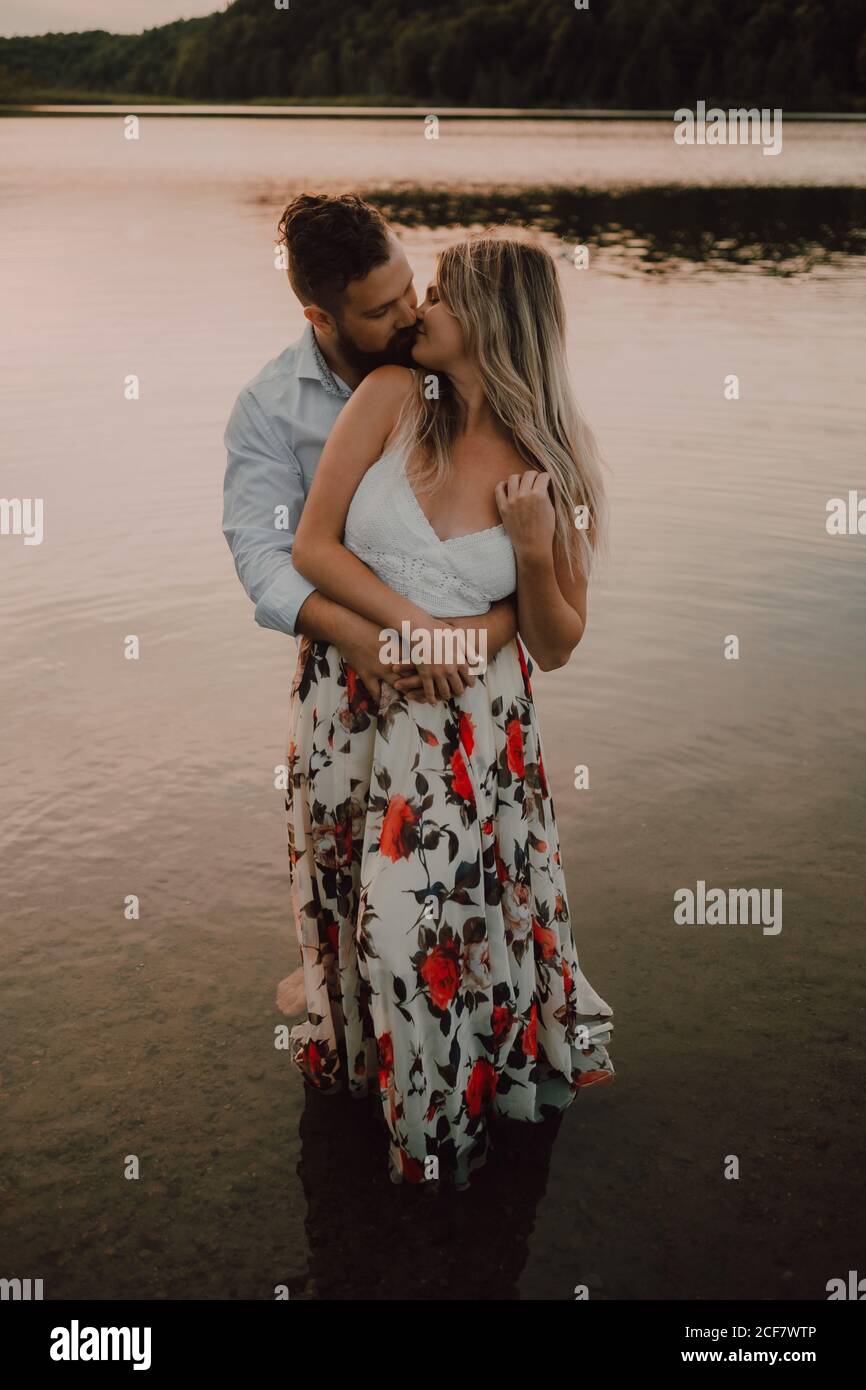 Adult bearded man hugging from behind Woman in casual clothes and ...