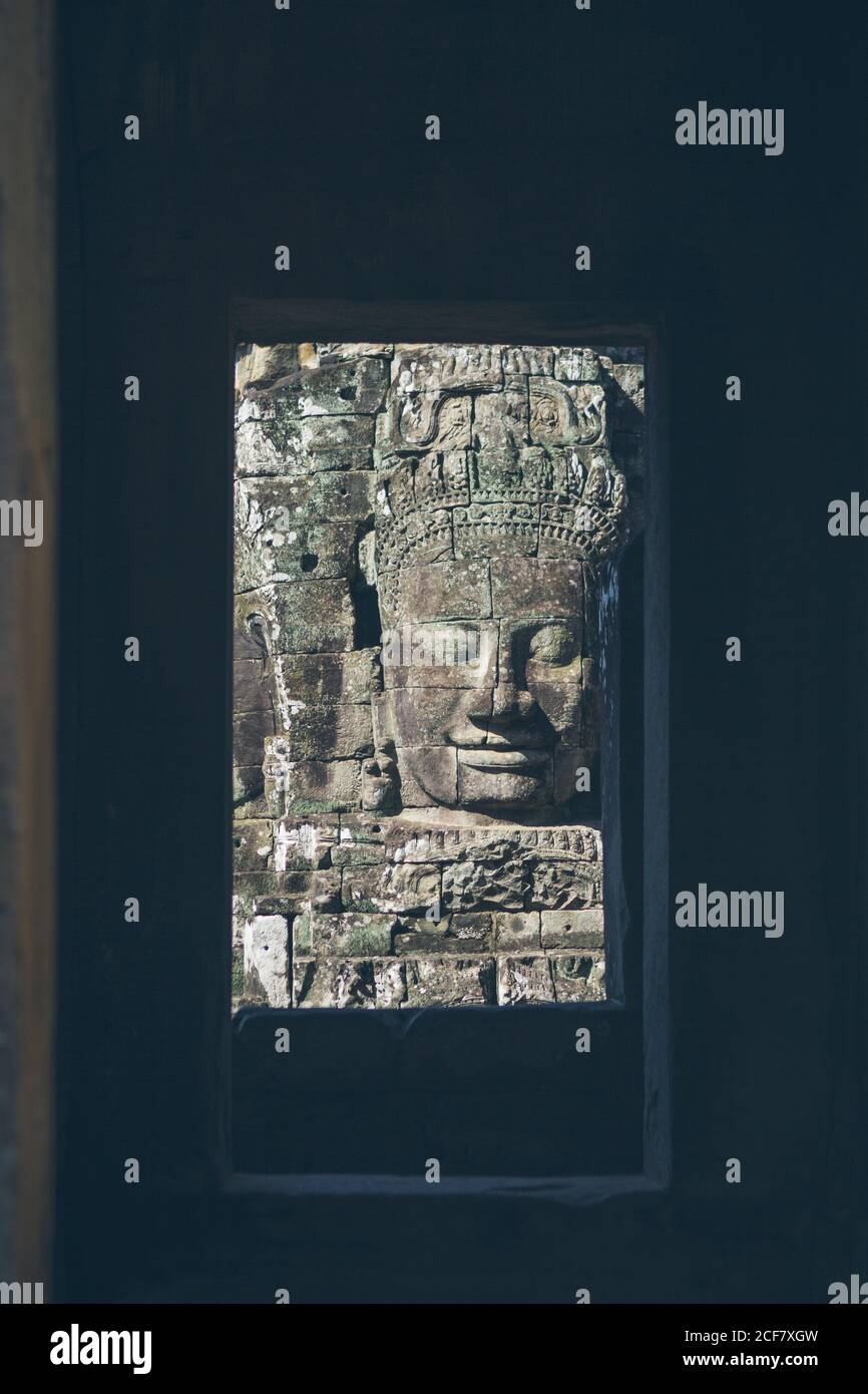 View of weathered face on wall of ancient oriental temple through ...