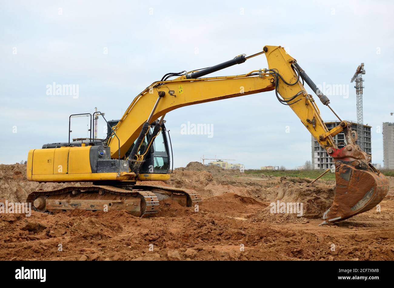Excavator with a large iron bucket on a construction site during road ...