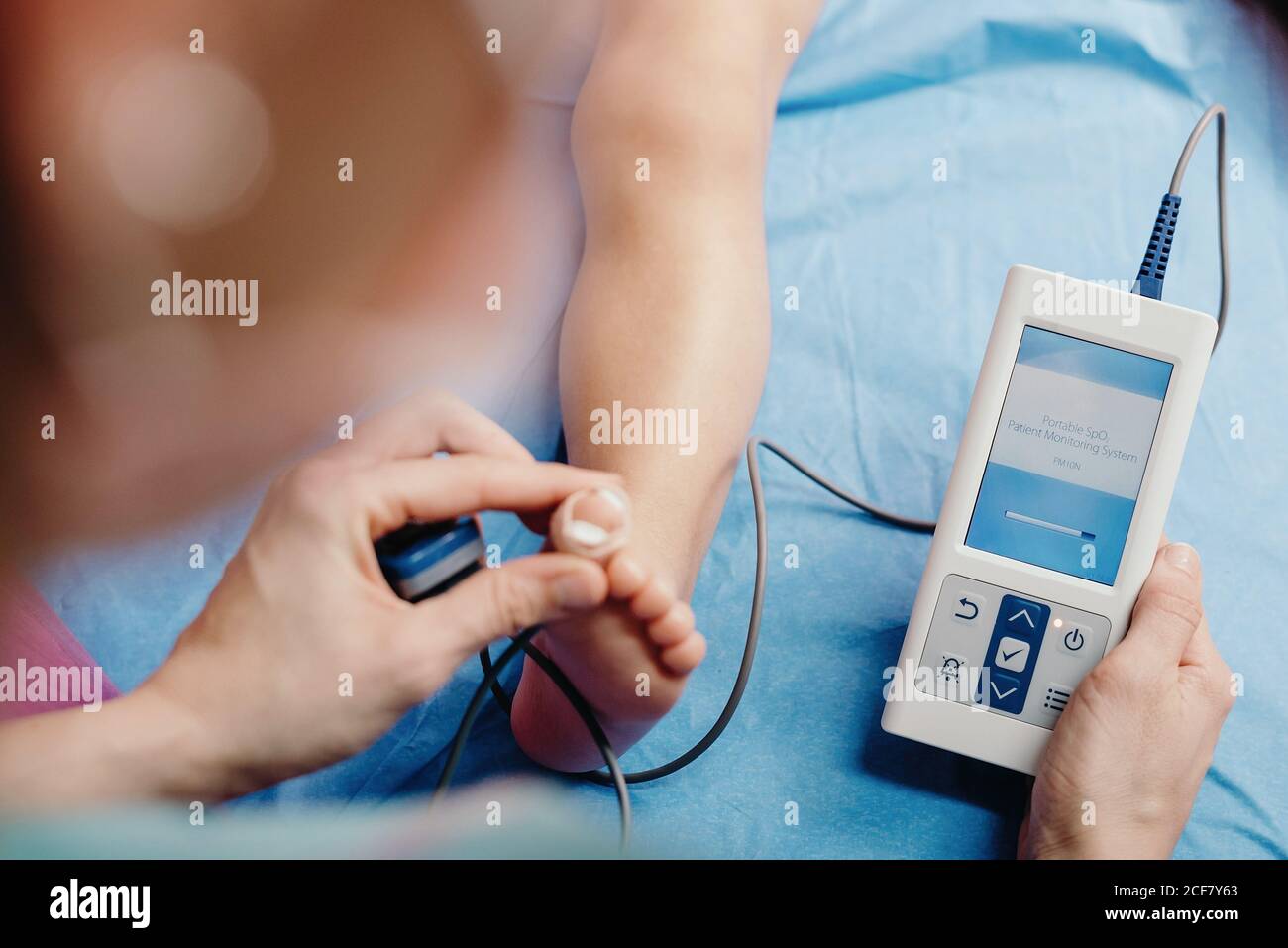 From above of crop medical specialist using pulse oximeter sensor while ...