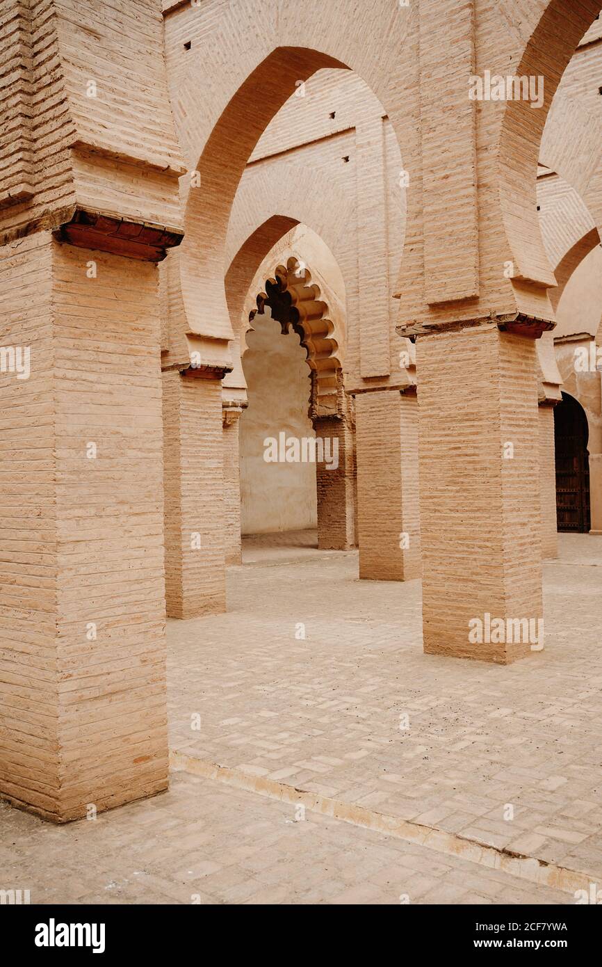 Aged stone building with columns and ornamental carved arches in old ...