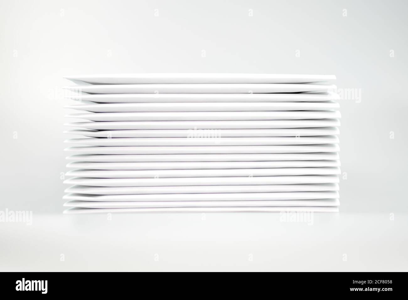 Stack of paper envelopes on white background. A pile of DVDs and CDs in ...