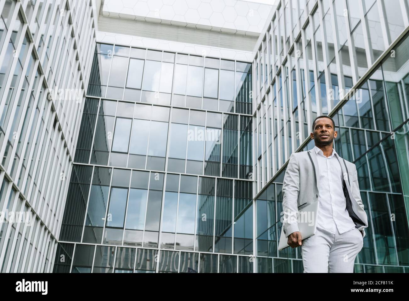 Black man holding laptop on street Stock Photo - Alamy