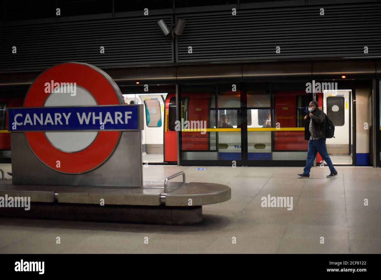 A commuter on the platform at Canary Wharf underground station, London ...