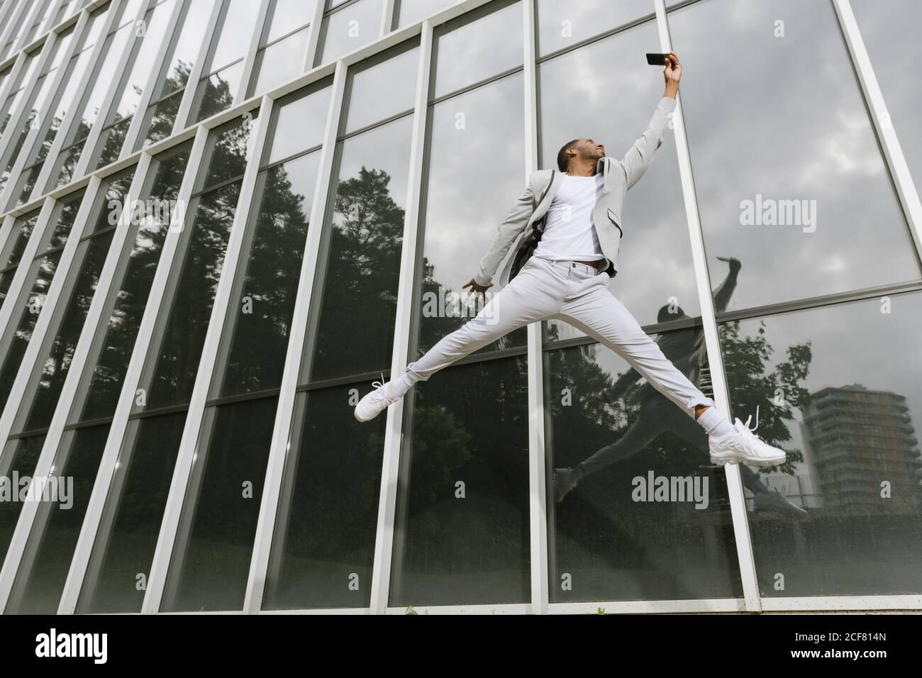 Enthusiastic black man jumping raising hand like superhero Stock Photo ...