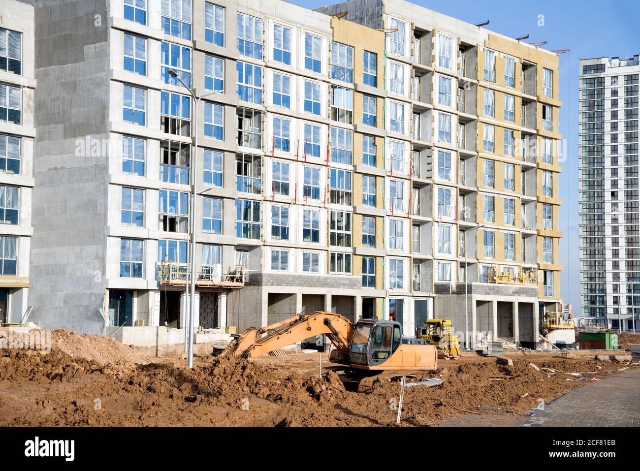 Excavator at building under construction. Backhoe digs the ground for ...