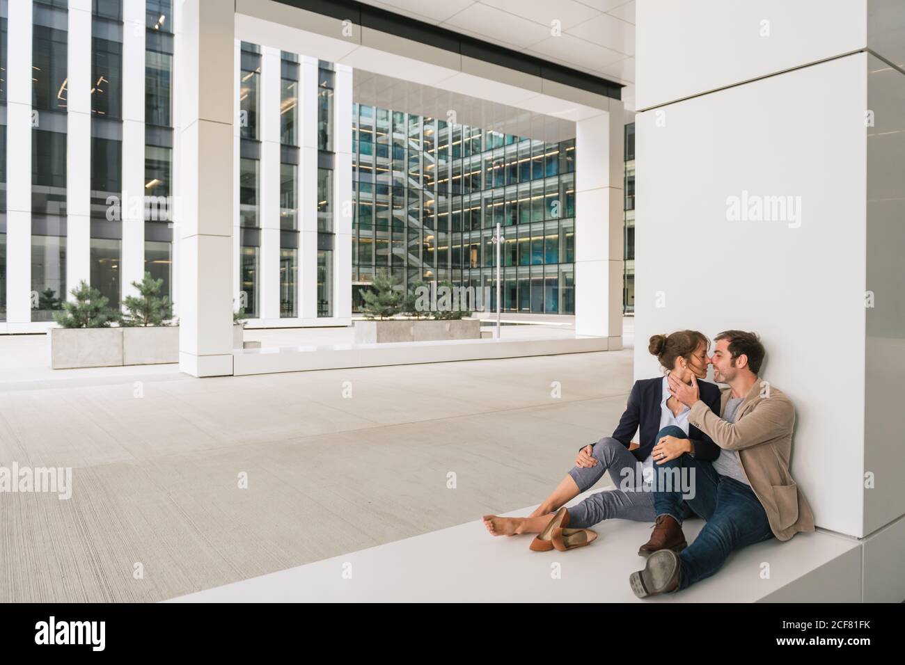 Male manager hugging and kissing girlfriend while sitting outside ...