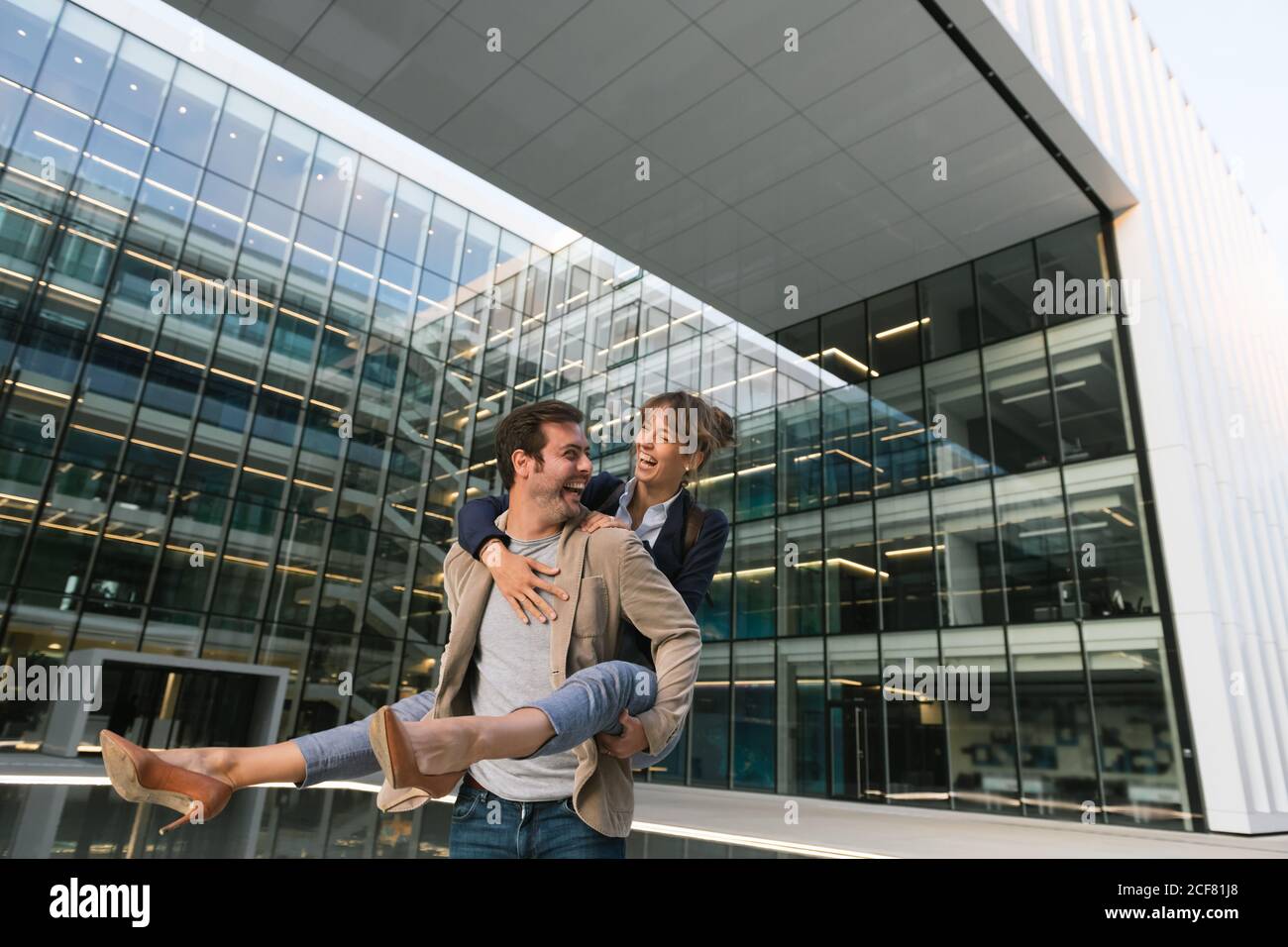 Happy adult man in casual clothes carry Woman piggyback while standing ...