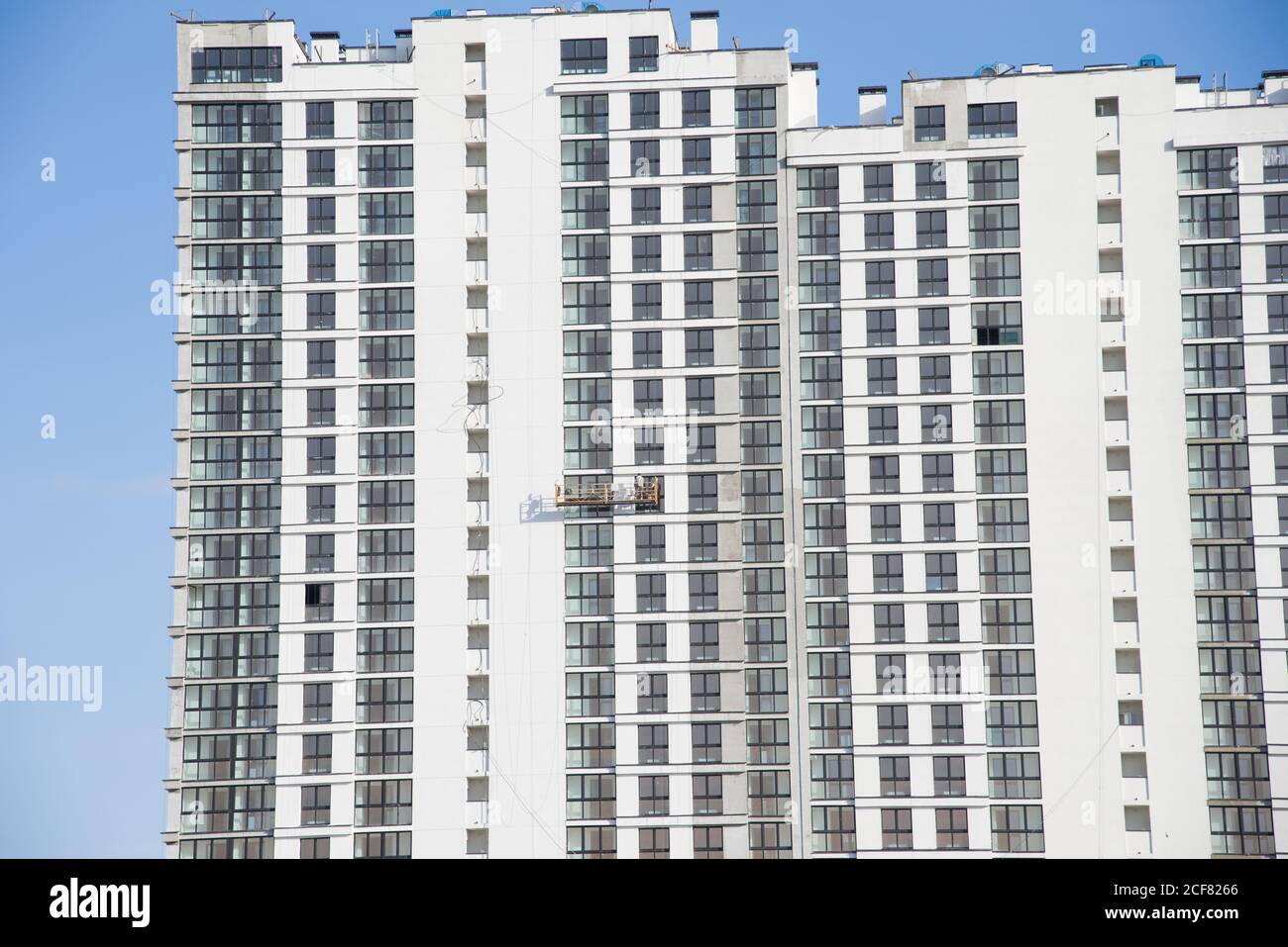 Suspended cradle on the facade of the skyscraper. Mobile scaffolding ...