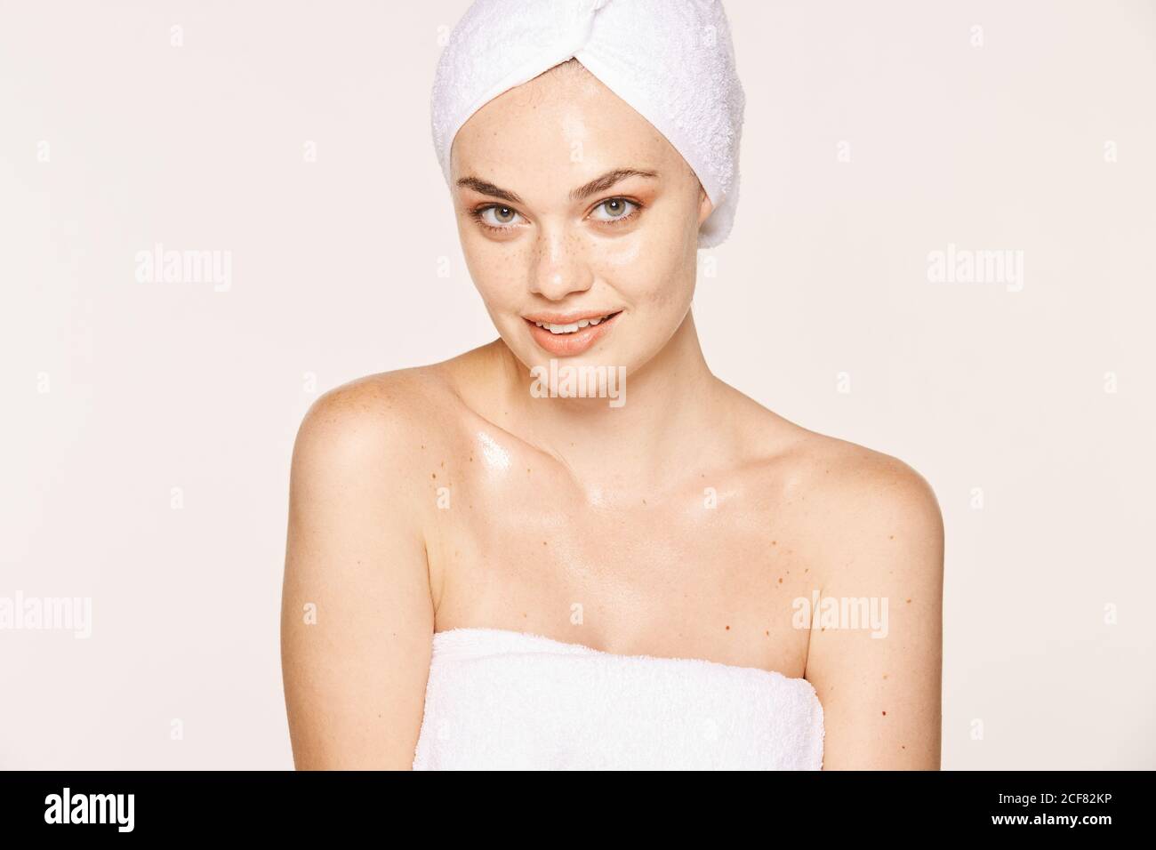 Good-looking Woman with moisturized skin posing in towel on face and ...