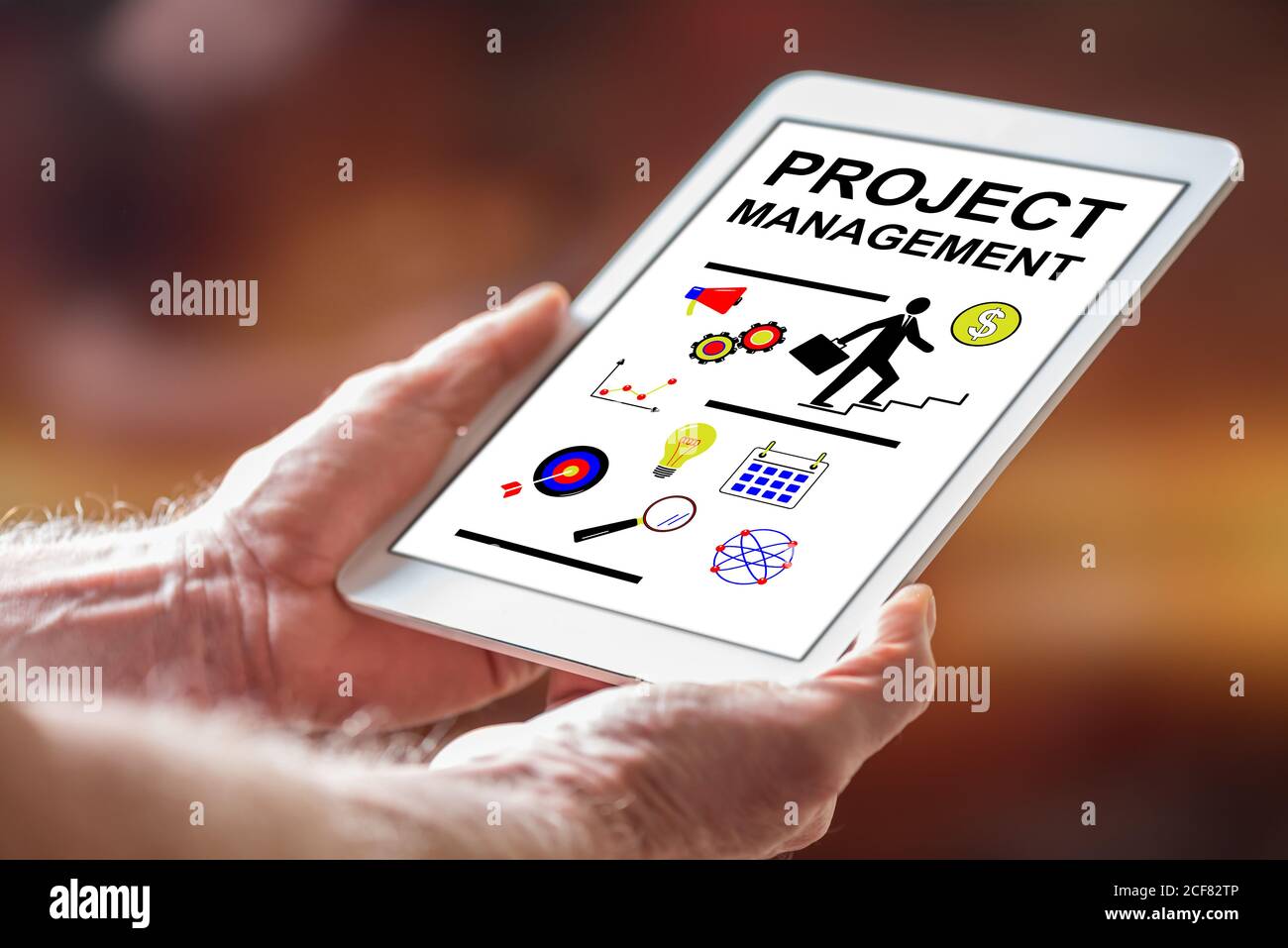 Man holding a tablet showing project management concept Stock Photo - Alamy