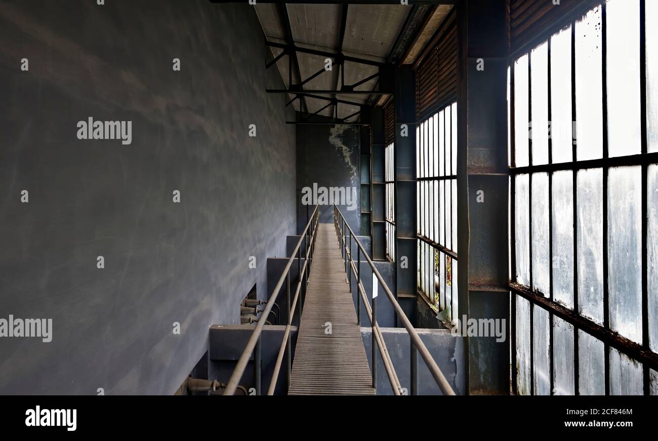 Narrow wooden bridge with steel handrails locating above rooms with ...