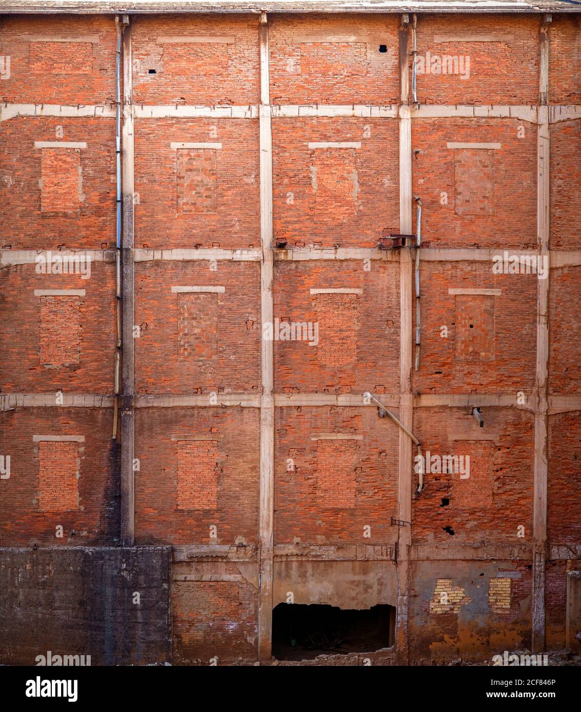Shabby old high wall of abandoned red brick building with brick windows ...
