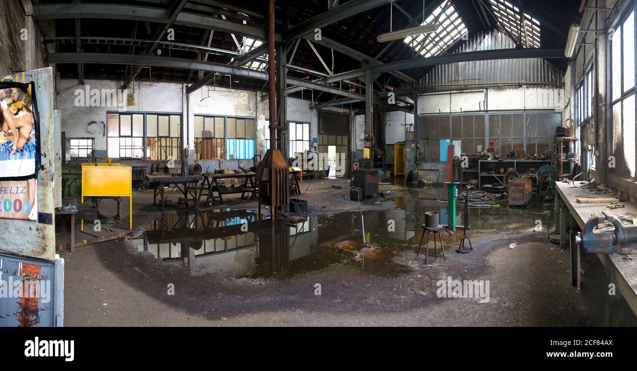 Abandoned dirty industrial room with leaking roof with metal banks ...