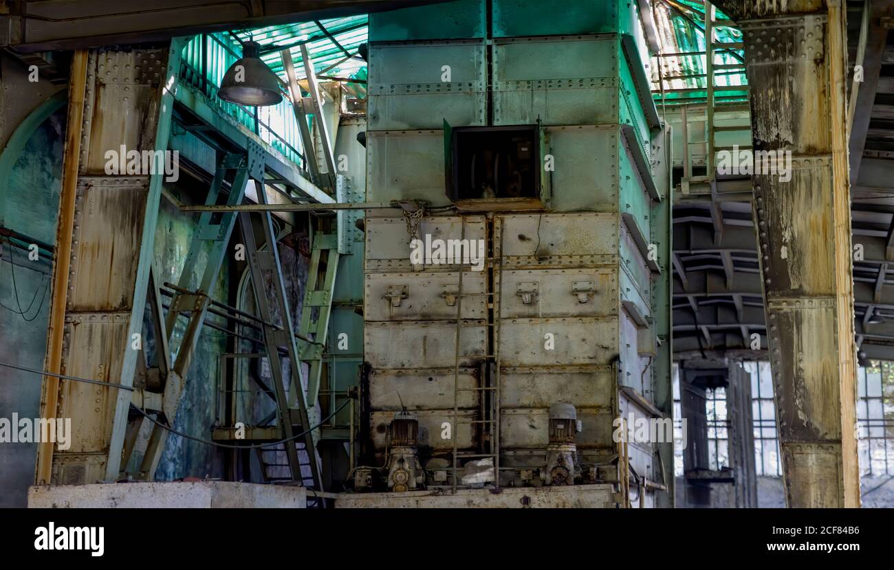 Rusty old tall multi level metal tower with iron staircase leading to ...
