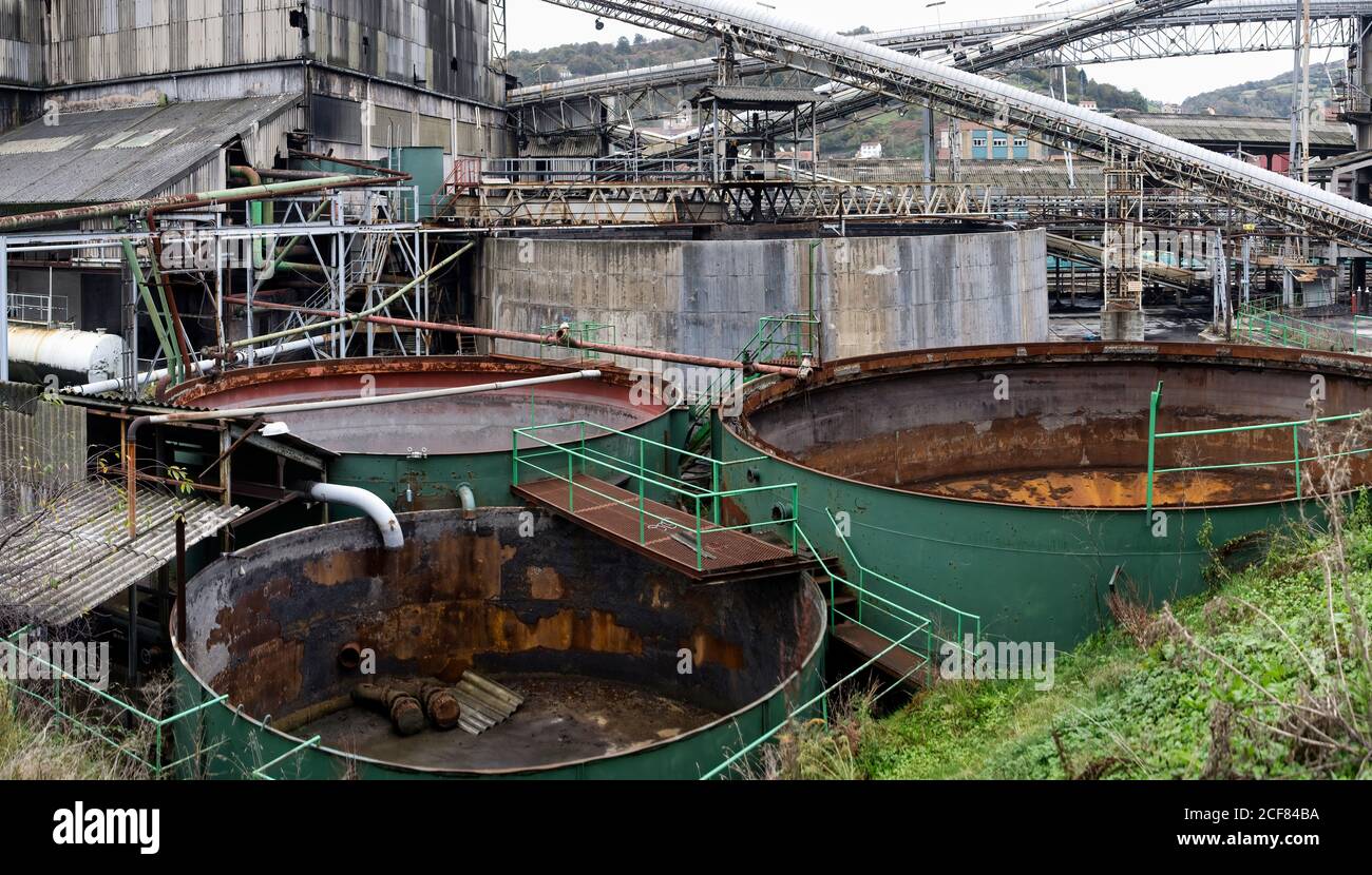 From above of huge rusted metal empty water tanks painted green ...
