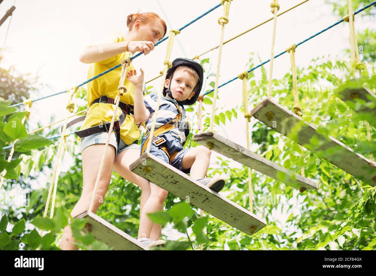 Kids climbing in adventure park. Boy enjoys climbing in the ropes ...