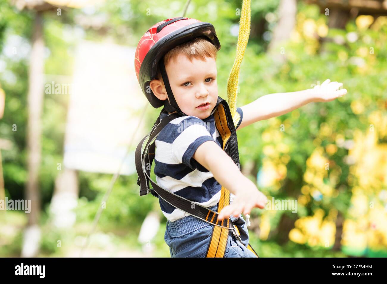Kids climbing in adventure park. Boy enjoys climbing in the ropes ...