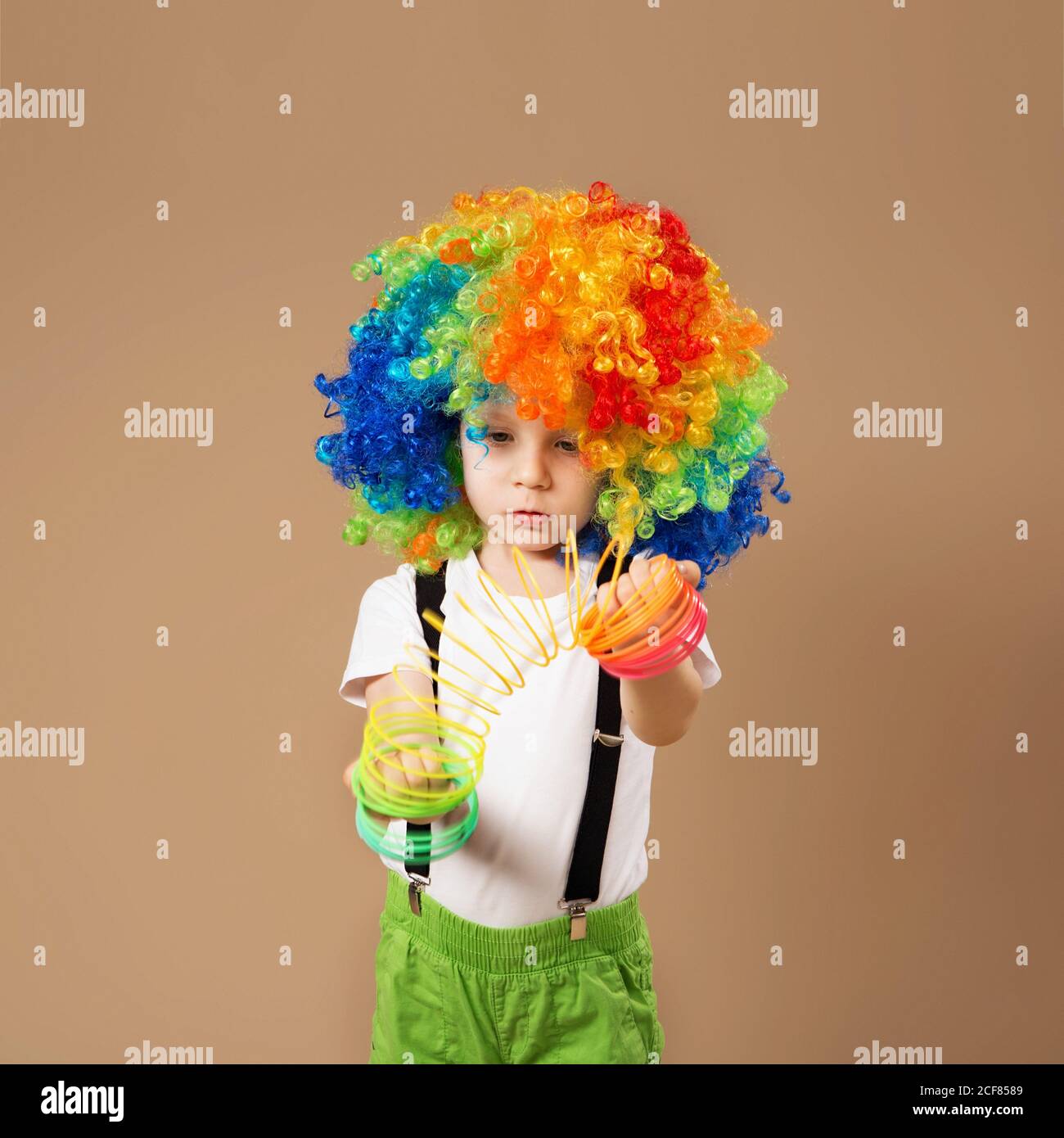 Happy clown boy with large colorful wig. Little boy in clown wig ...