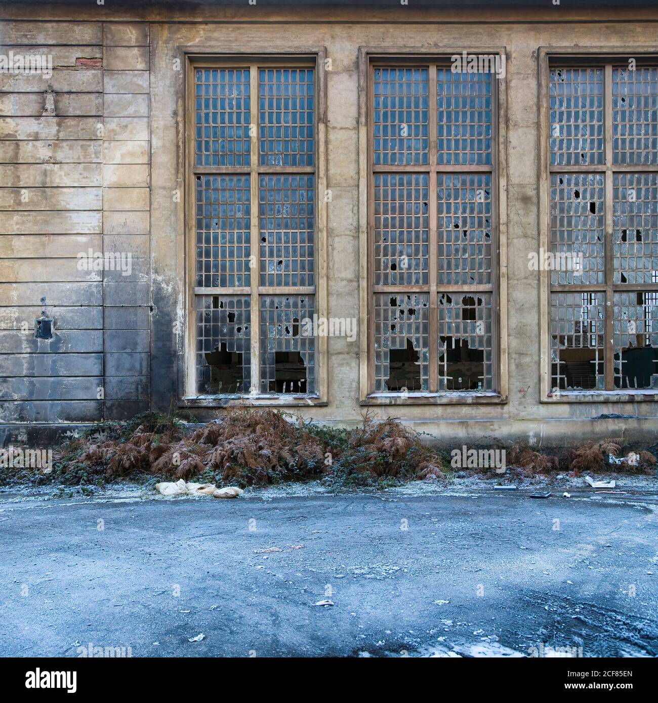 Exterior of abandoned stone industrial building with narrow windows ...
