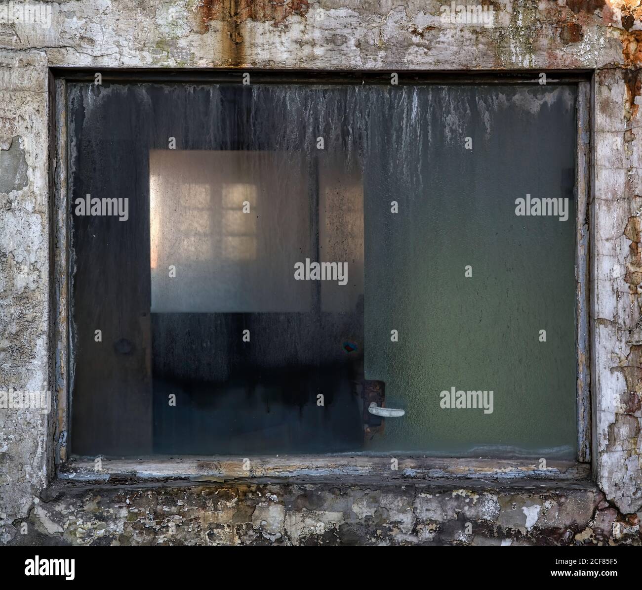 Fragment of weathered stone wall with small dirty window of derelict ...