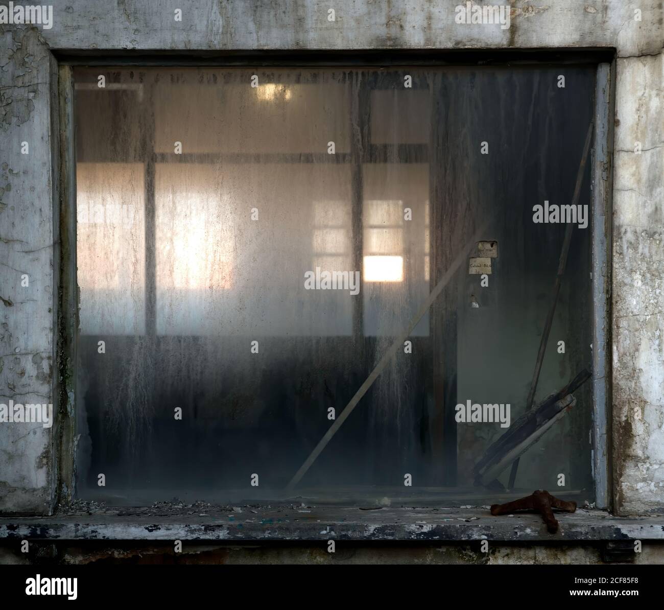 Fragment of weathered stone wall with small dirty window of derelict ...