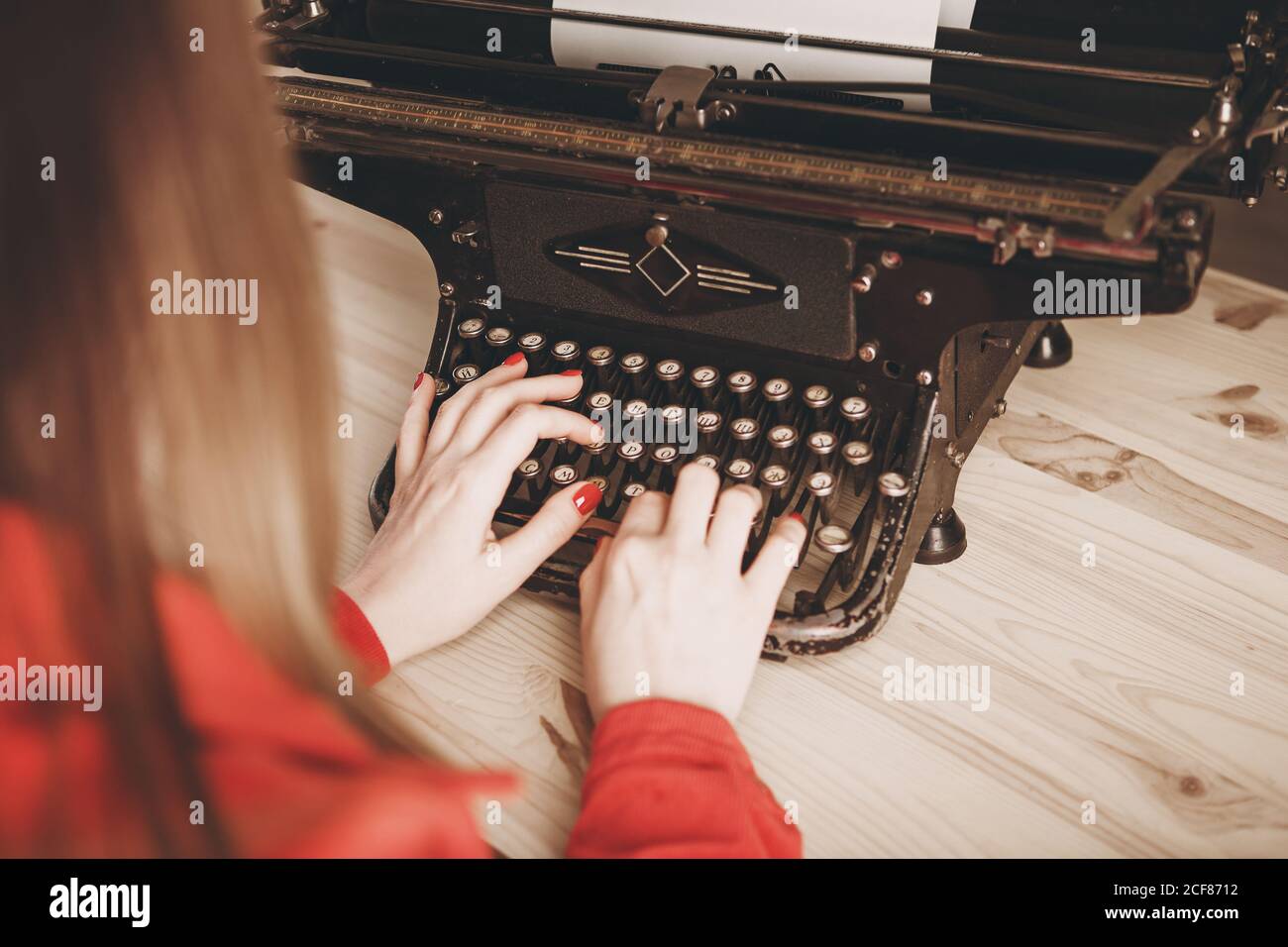 Secretary at old typewriter with telephone. Young woman using ...