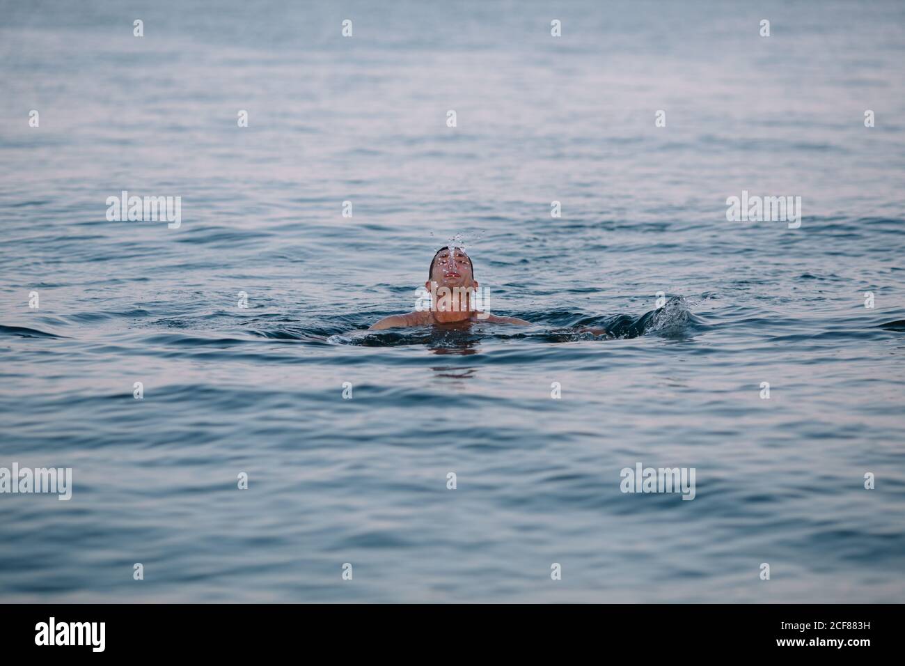 Satisfied male swimmer during healthy active leisure in deep calm sea ...