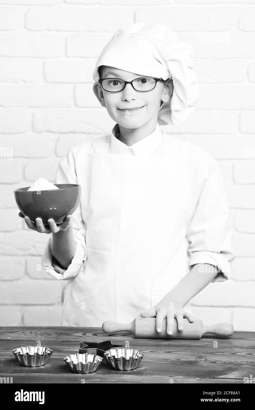 young boy small cute cook chef in white uniform and hat on smiling face ...