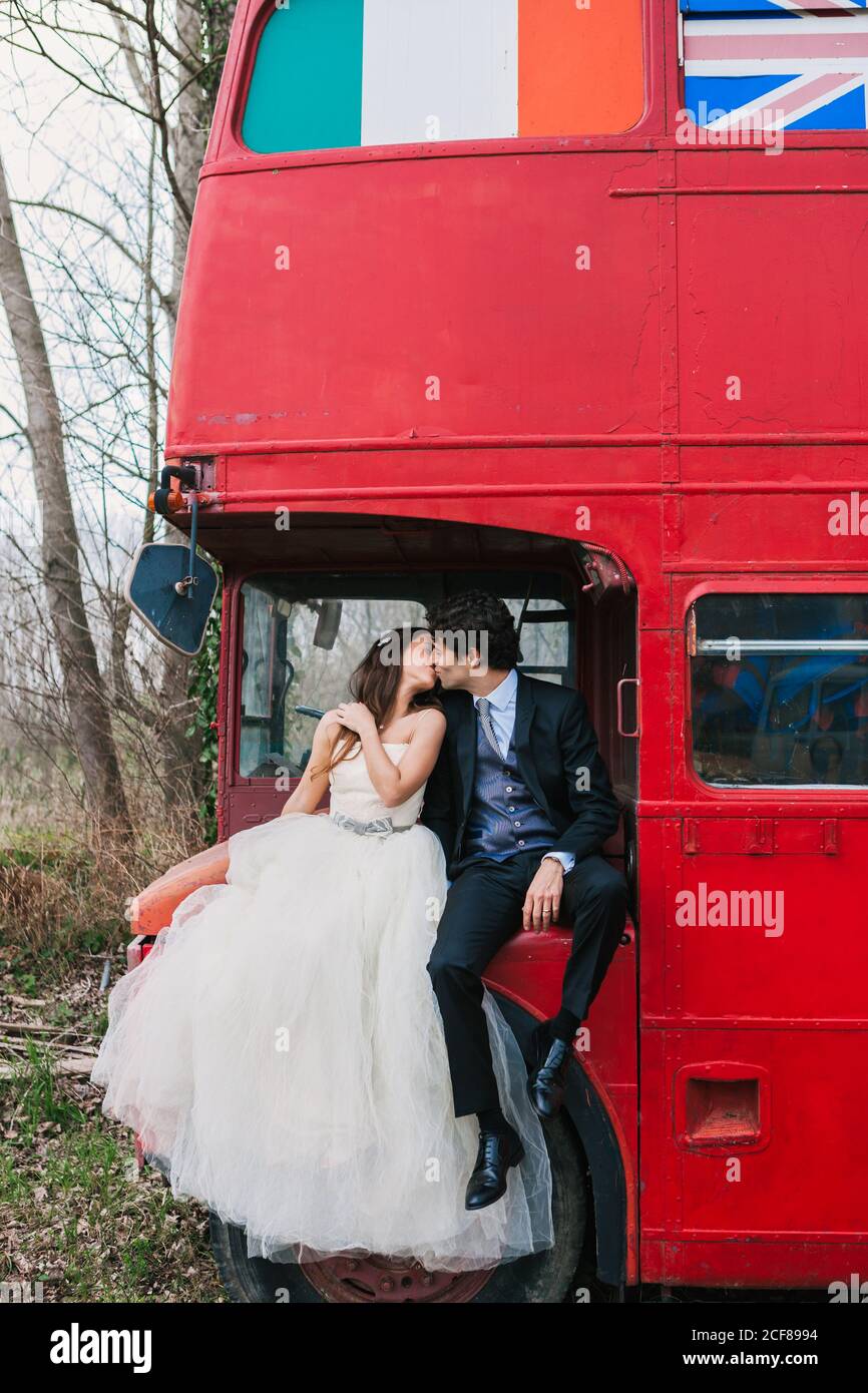 bride and groom in love embracing and kissing in forest while standing ...