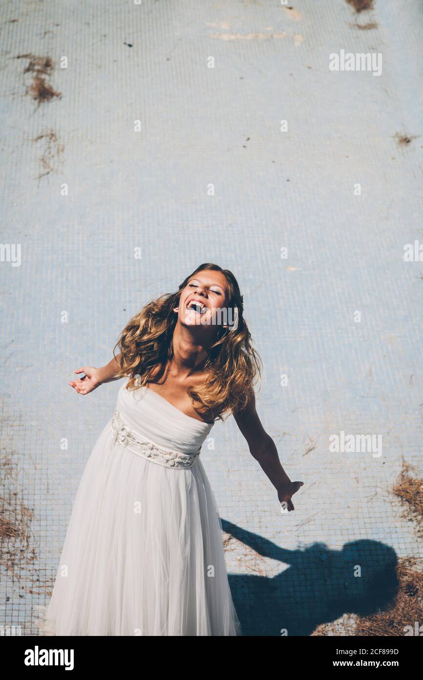From above view of happy young blond bride in elegant white wedding ...