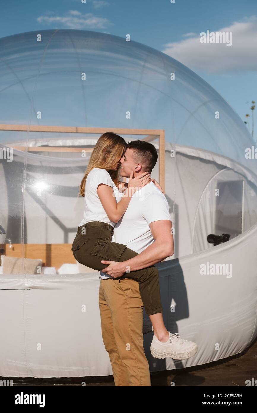 Side view of passionate man holding and hugging young Woman while ...