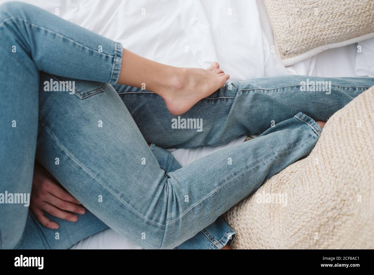 From above crop legs of romantic couple in love hugging in bedroom ...